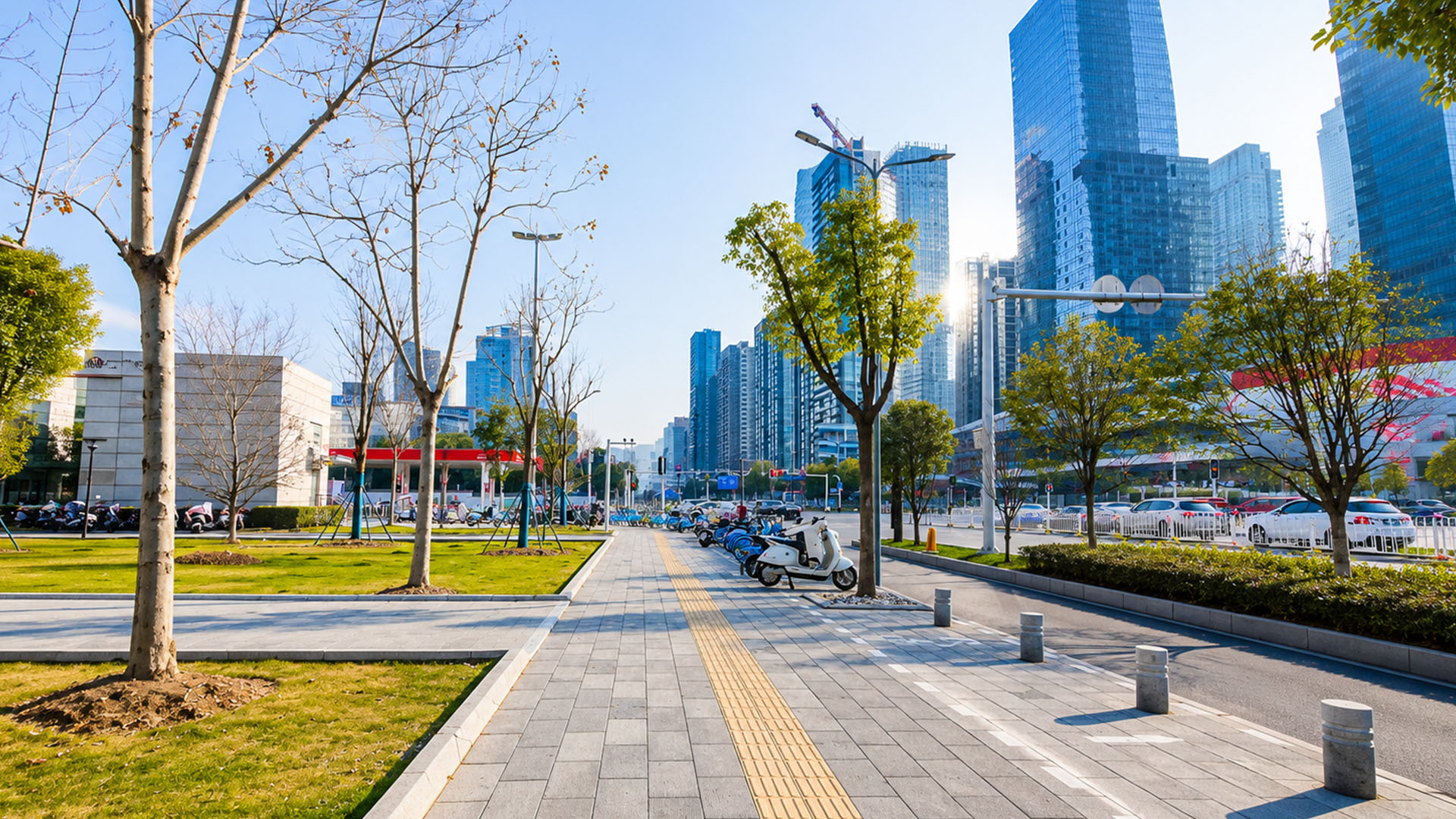 Glass skyscrapers and parked scooters reveal a modern street pulse