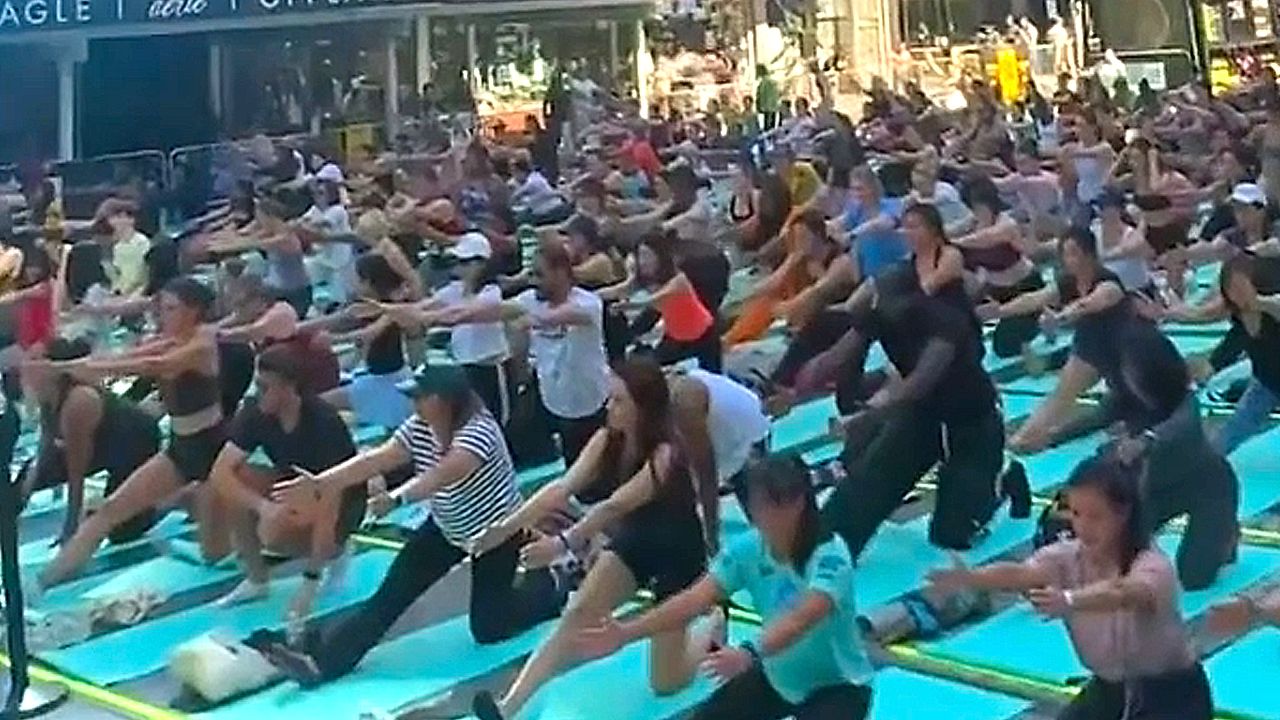 New Yorkers welcome summer solstice with massive Times Square yoga session