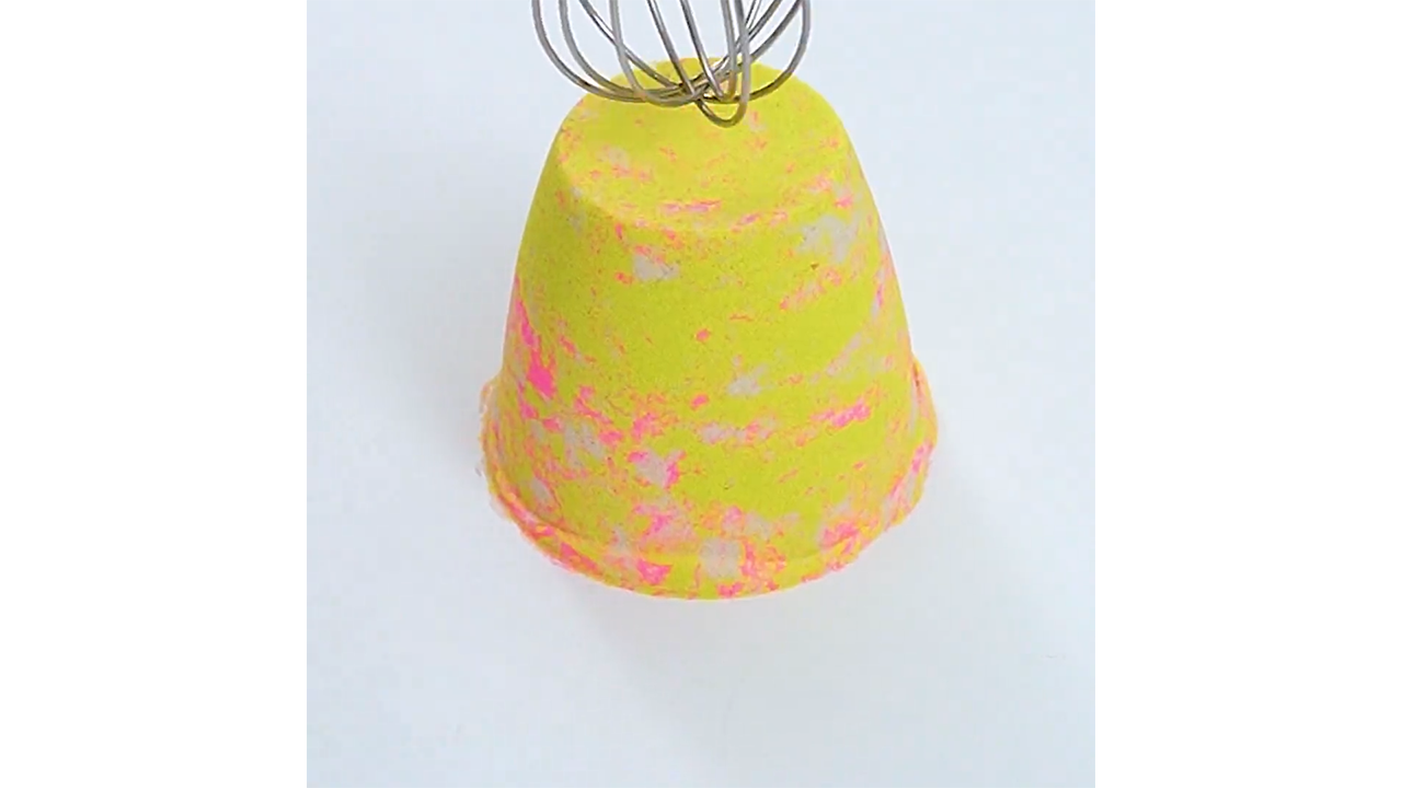Satisfying whisk pressing neon yellow sand tower creating smooth spiral ...