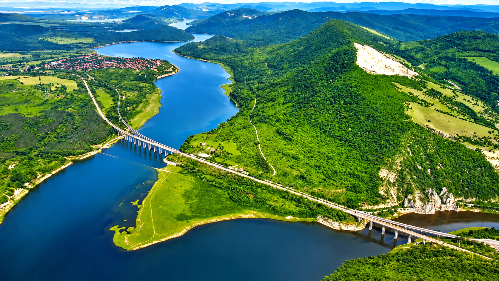 A deep green river valley crossed by mountain bridges