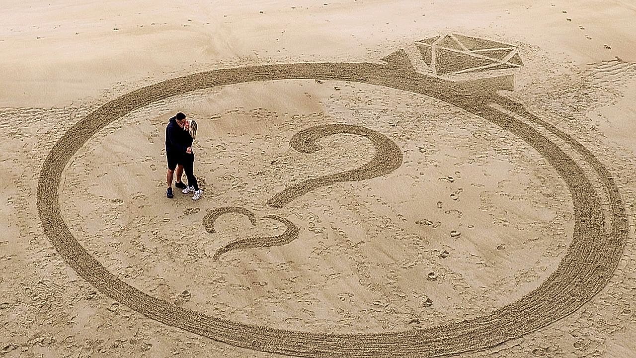 Man has giant ring carved into sand to propose to girlfriend at the beach