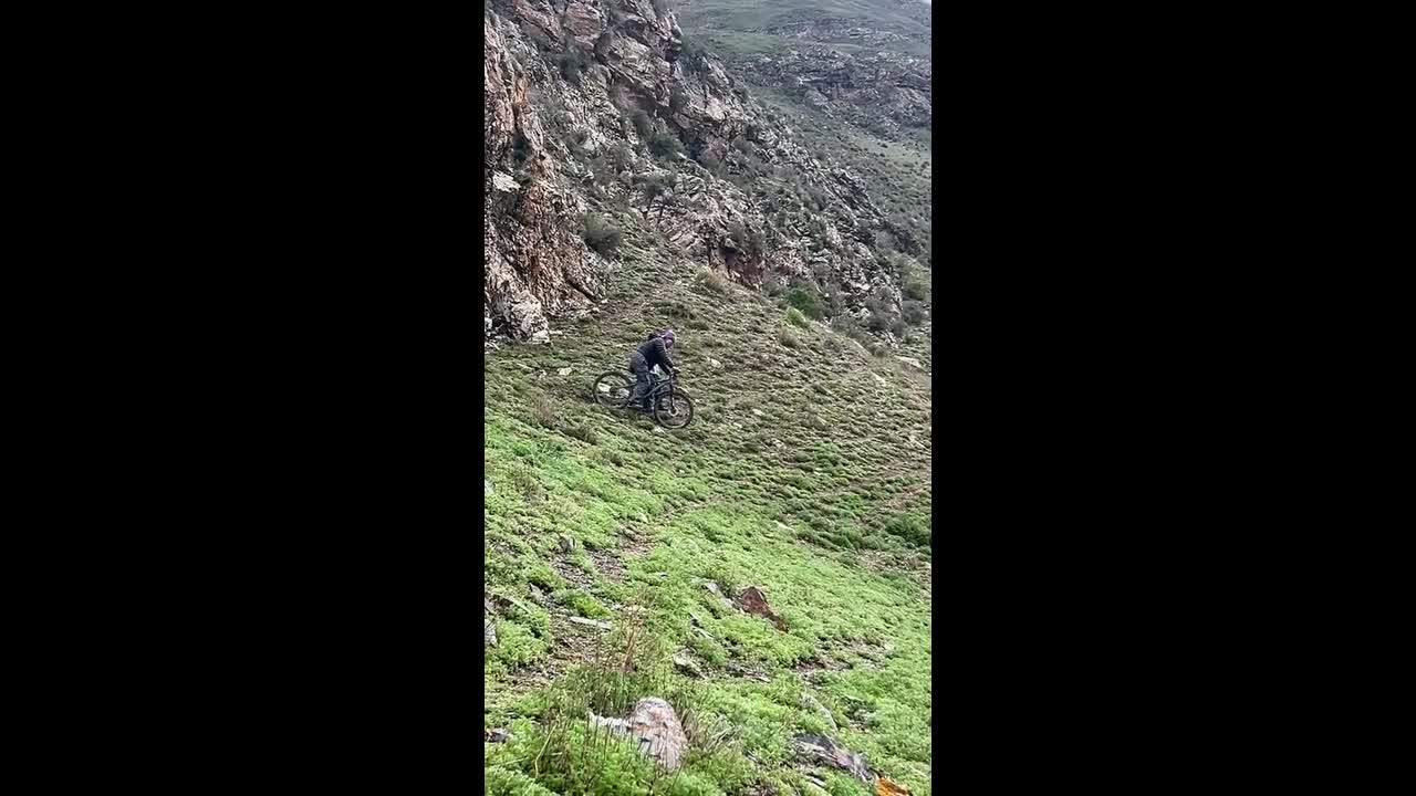 Cyclist loses balance on rocky downhill slope in Tibet, China