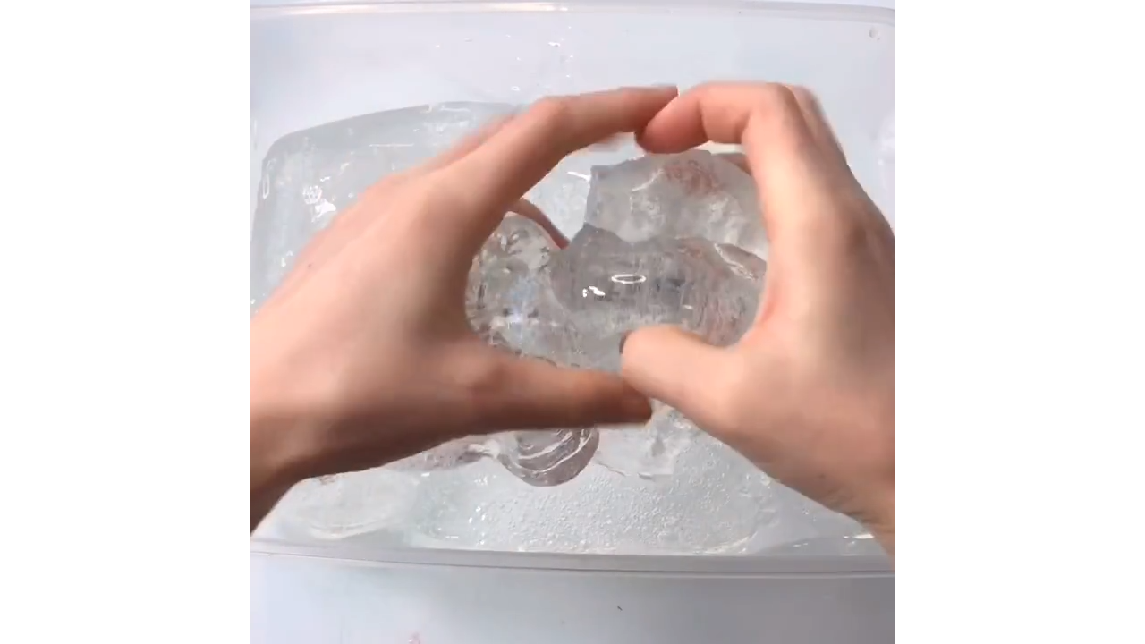 Poking and squeezing crystal clear ice slime creating glossy bubble pops