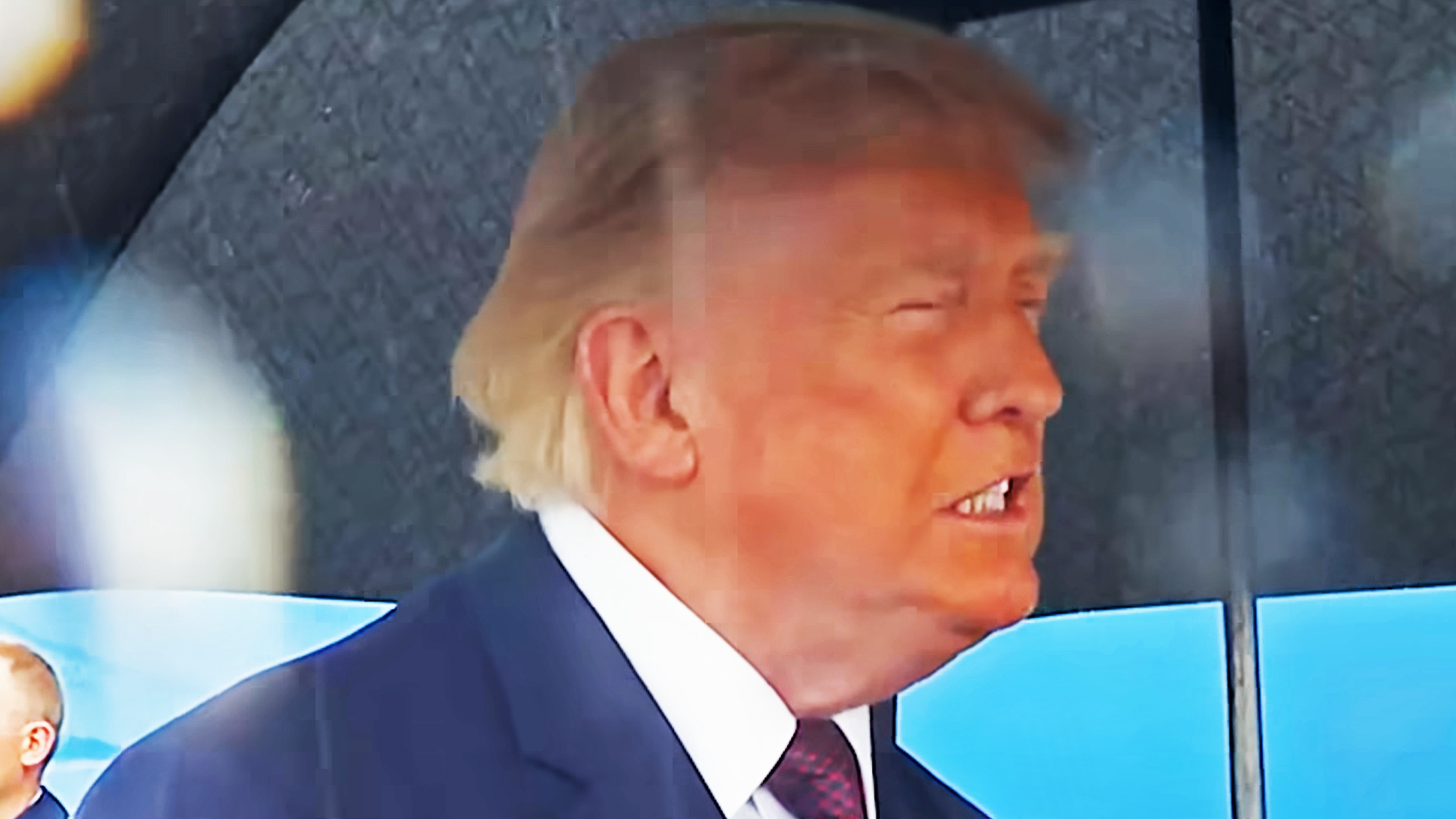 Trump struggles with umbrella
