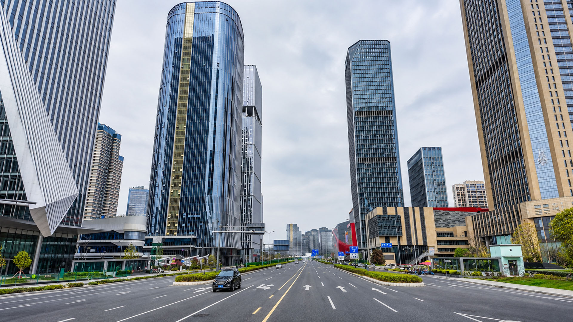 A nearly empty avenue frames China’s massive modern tower wall