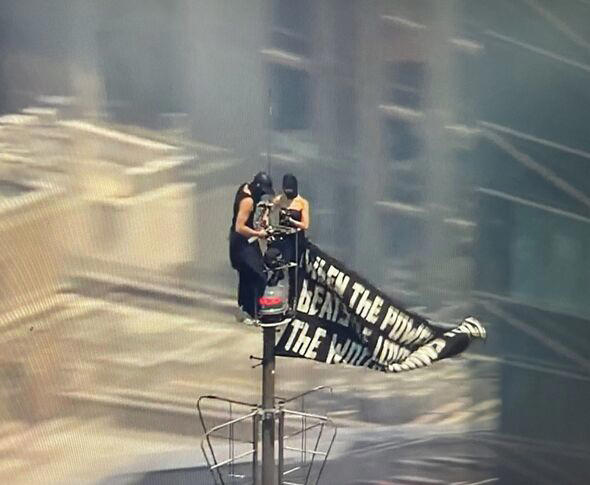 Two masked people climb to top of New York's Empire State Building as ...