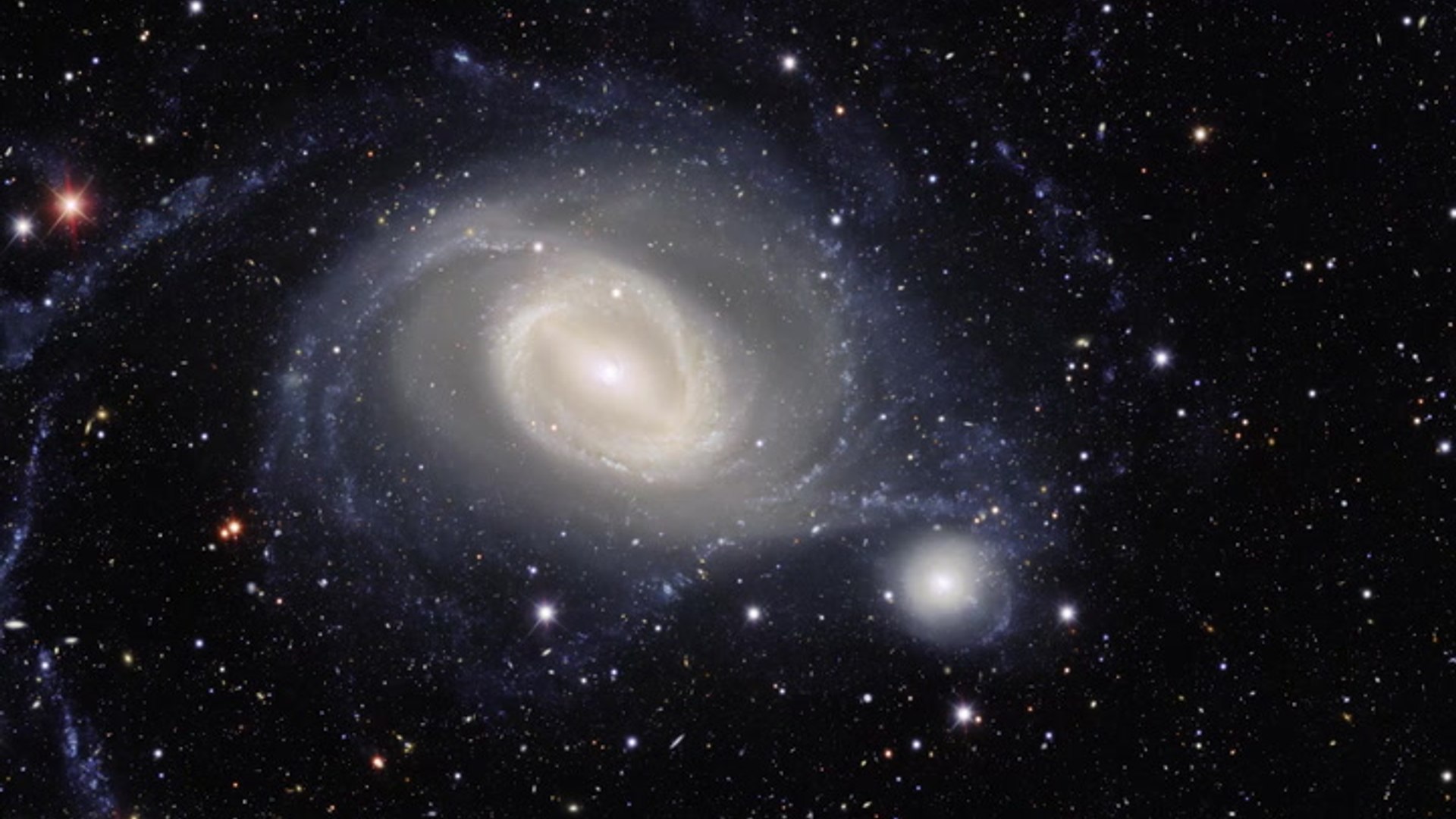 Spiral galaxy arm wraps around companion in amazing imagery