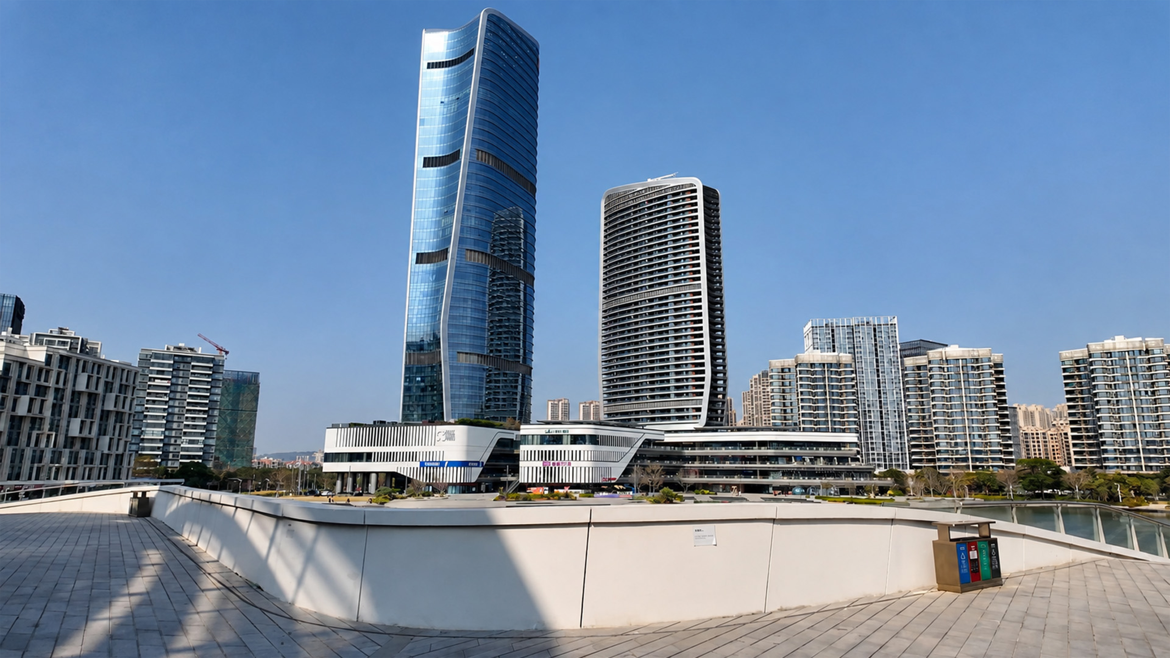 A striking glass tower dominates a skyline of modern residential and ...
