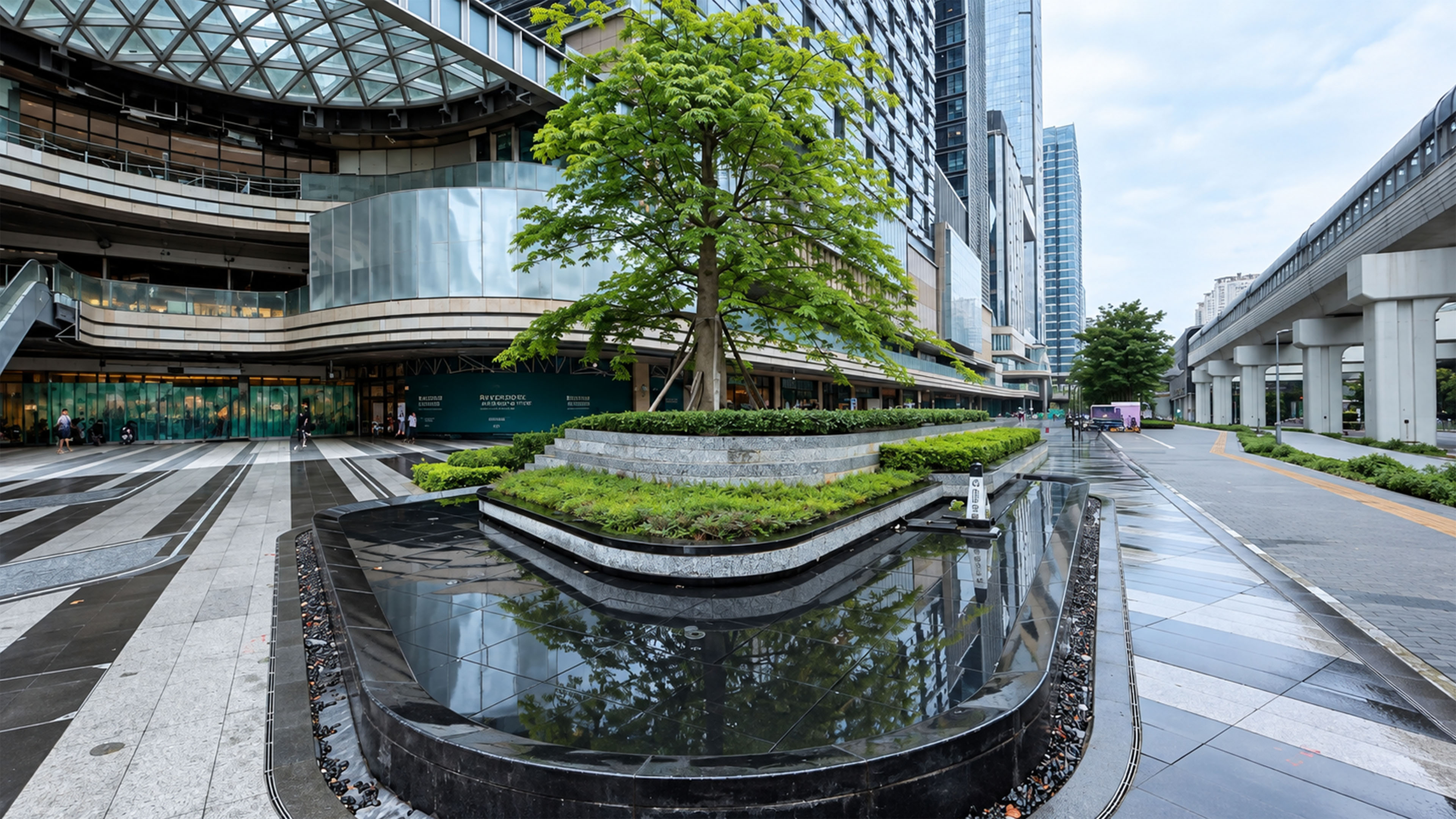 Contemporary commercial buildings rise beside an elevated transit line ...