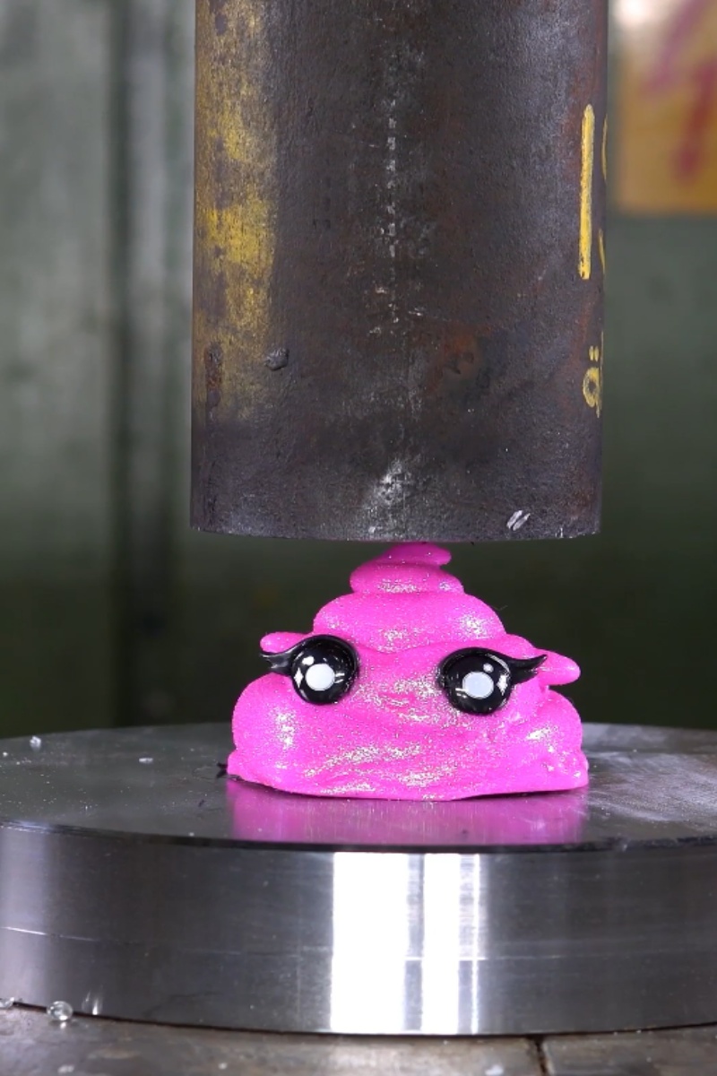Crushing a pink poop toy with a hydraulic press