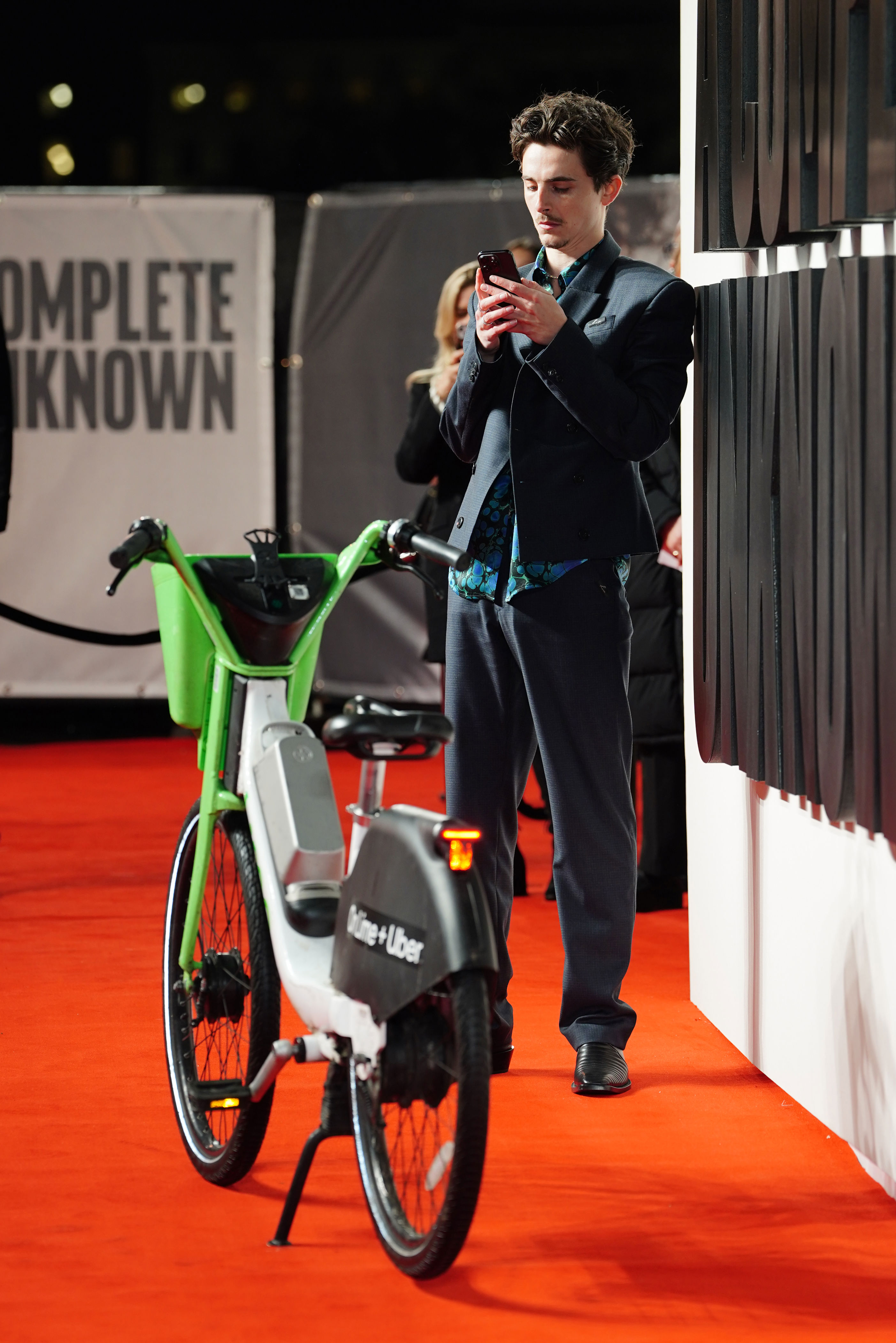 Timothee Chalamet arrives at A Complete Unknown UK premiere on a Lime bike